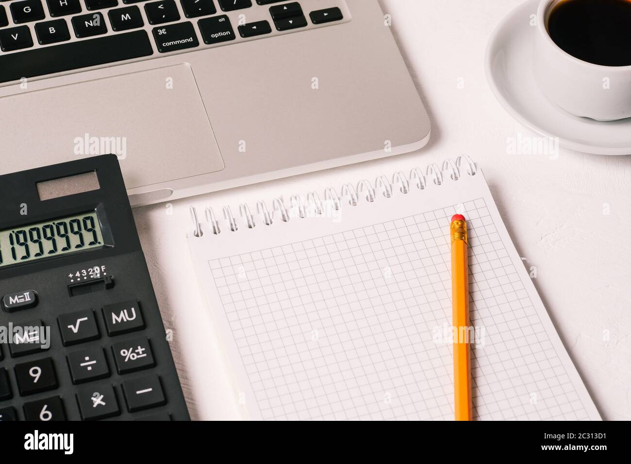 A calculator, a laptop, a Cup of coffee, and a notebook with a pencil ...