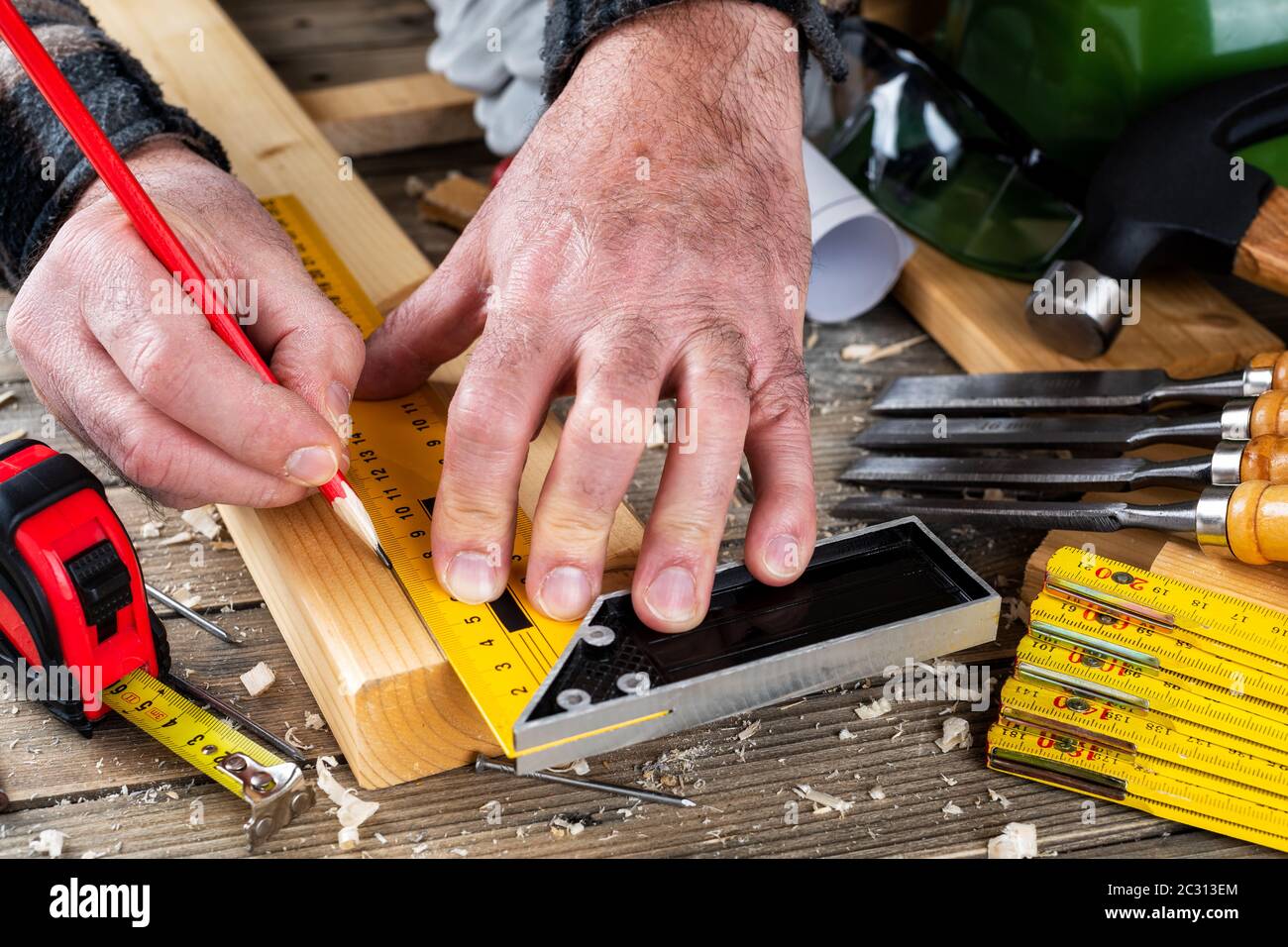 Top view. Carpenter with pencil and the carpenter's square draw the ...