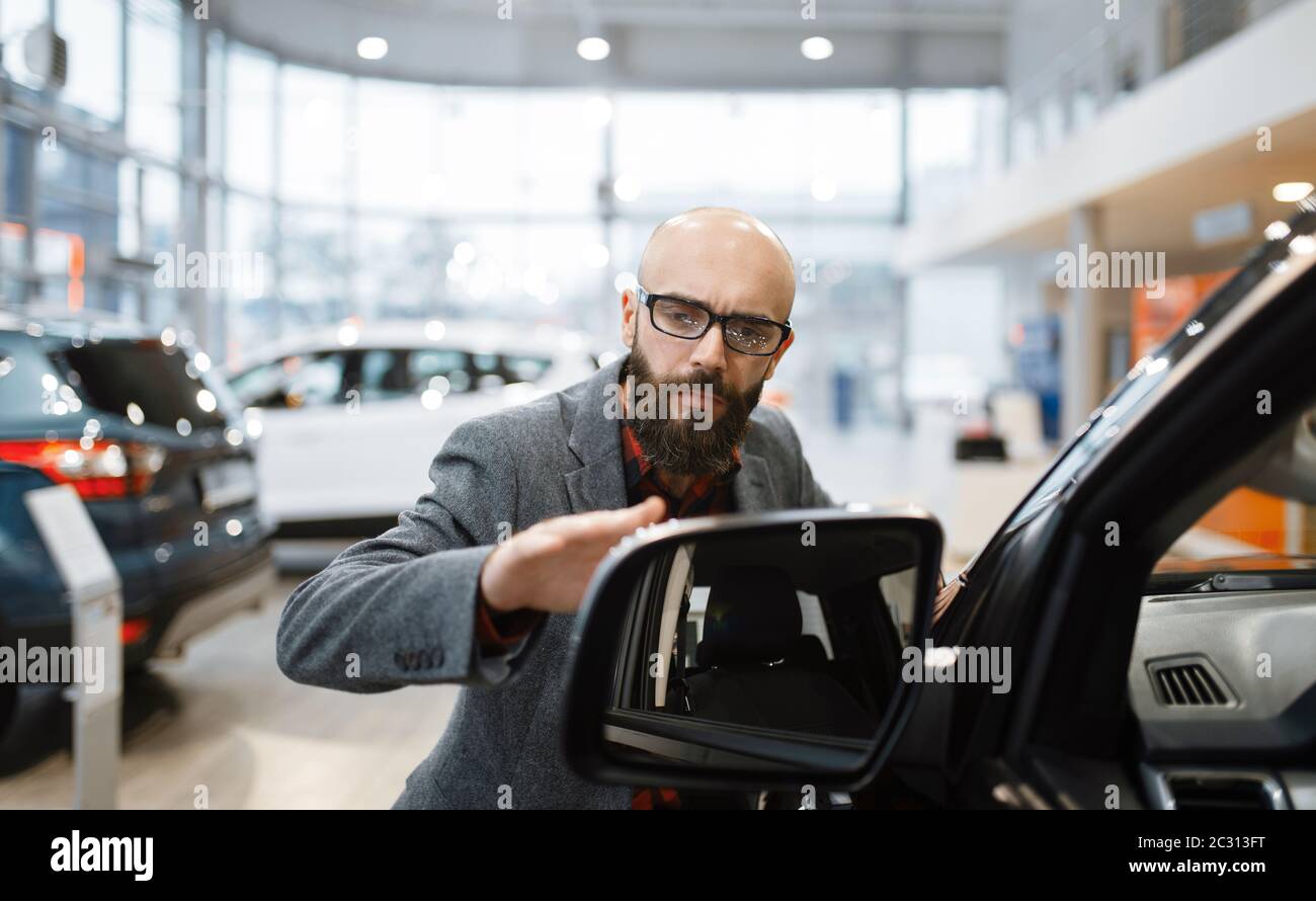 Man checks the paintwork of new pickup truck in car dealership ...