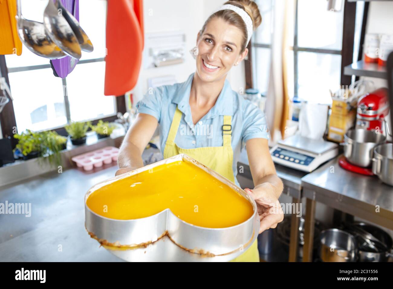Happy female chef offering delicious cake Stock Photo - Alamy