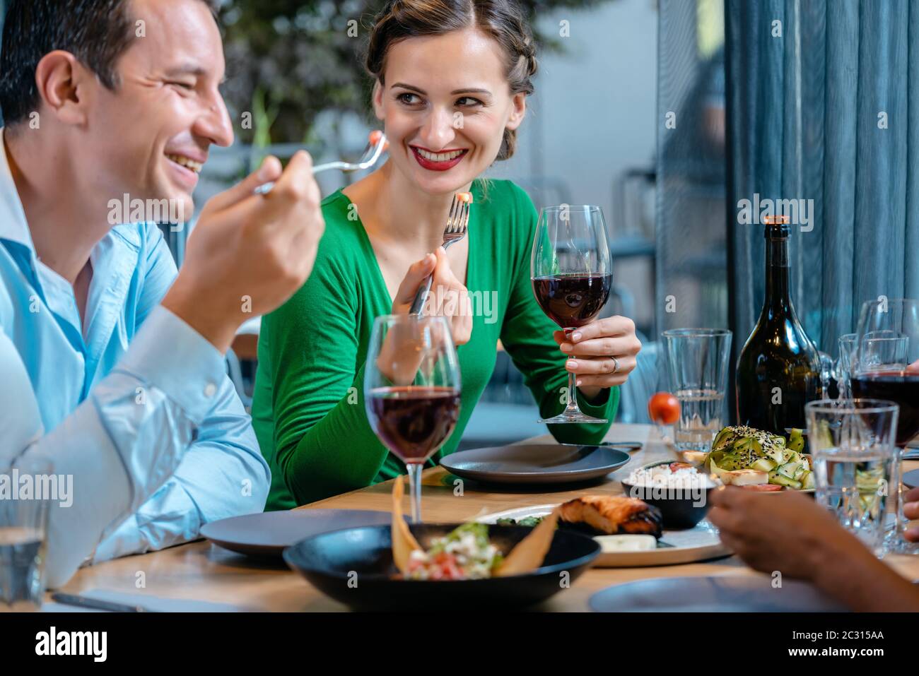 People having fun eating and drinking in a upscale restaurant toasting ...