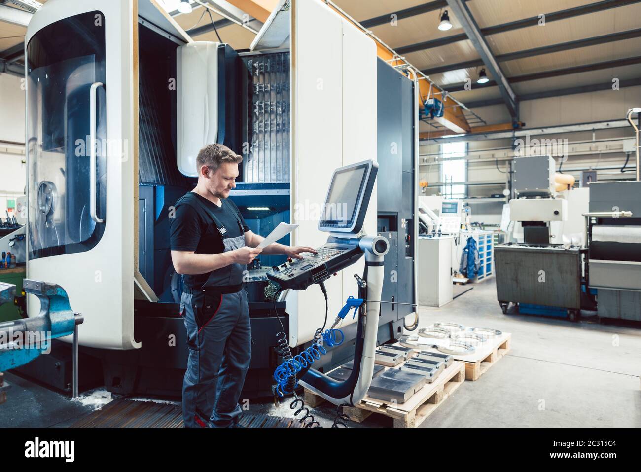 Metalworker operating cnc machine hi-res stock photography and images ...