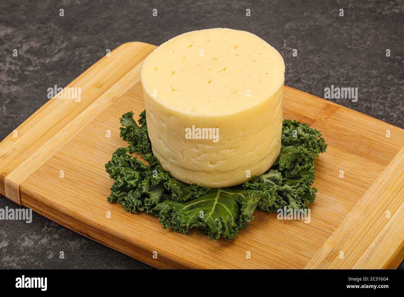 Yellow round dairy soft cheese piece Stock Photo - Alamy