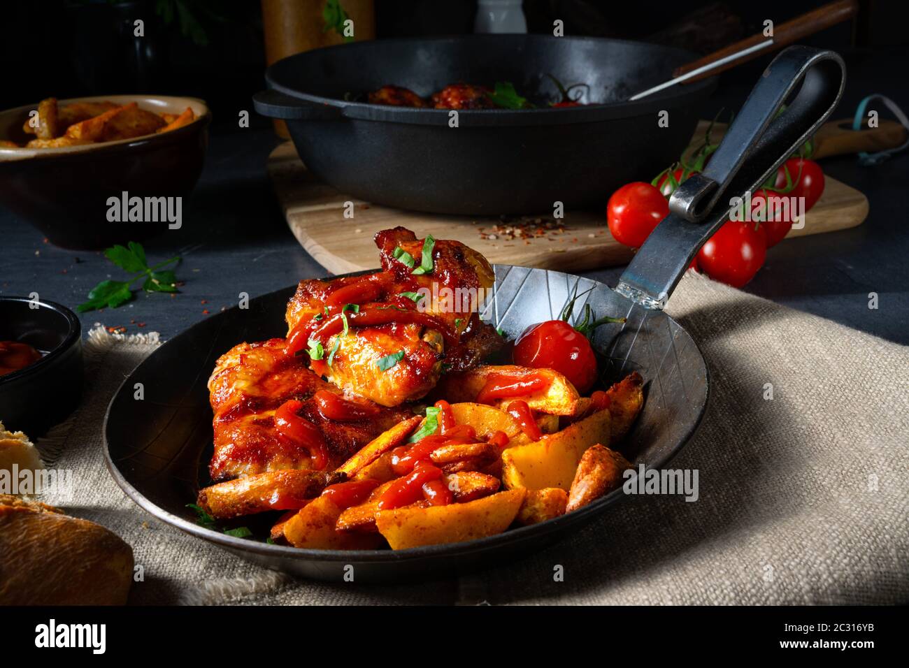 Rustic chicken wings in honey with potato wedges Stock Photo - Alamy