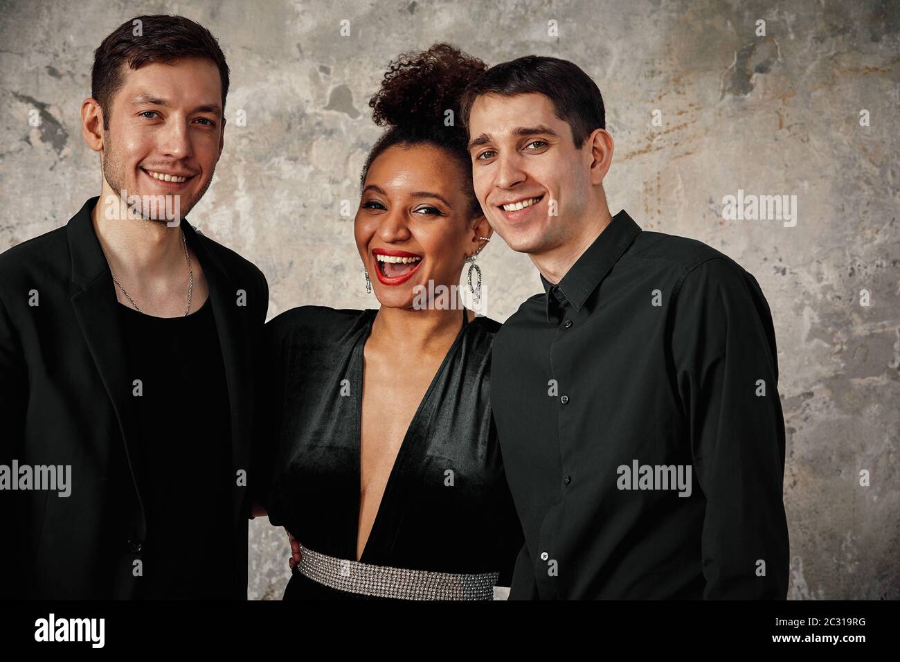 Beautiful fashion models posing on grey background with white box ...