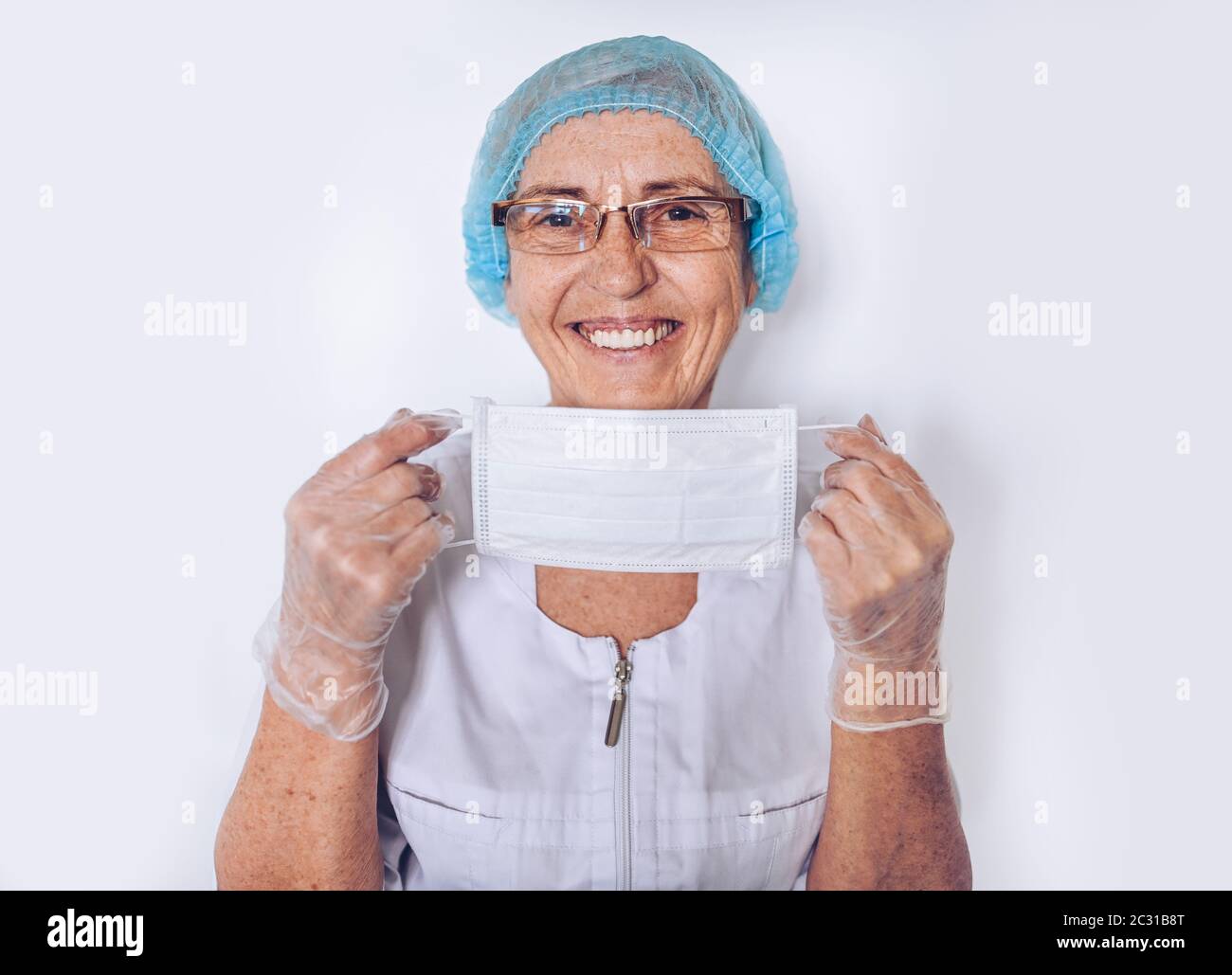 Elderly happy mature woman doctor or nurse in a white medical coat ...