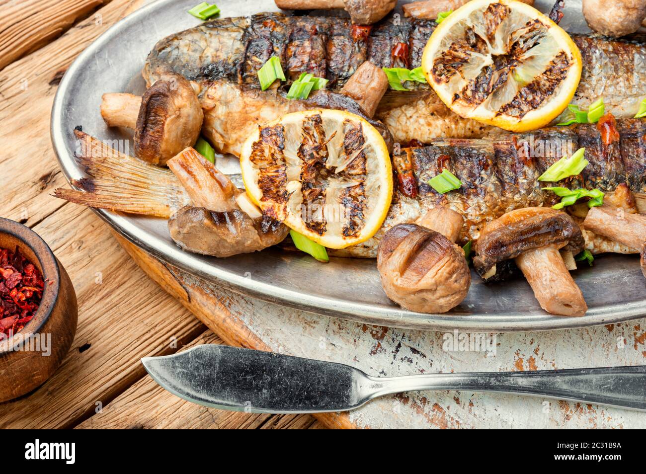 Baked whole pelengas fish with mushrooms and lemon.Sea food.Grilled ...