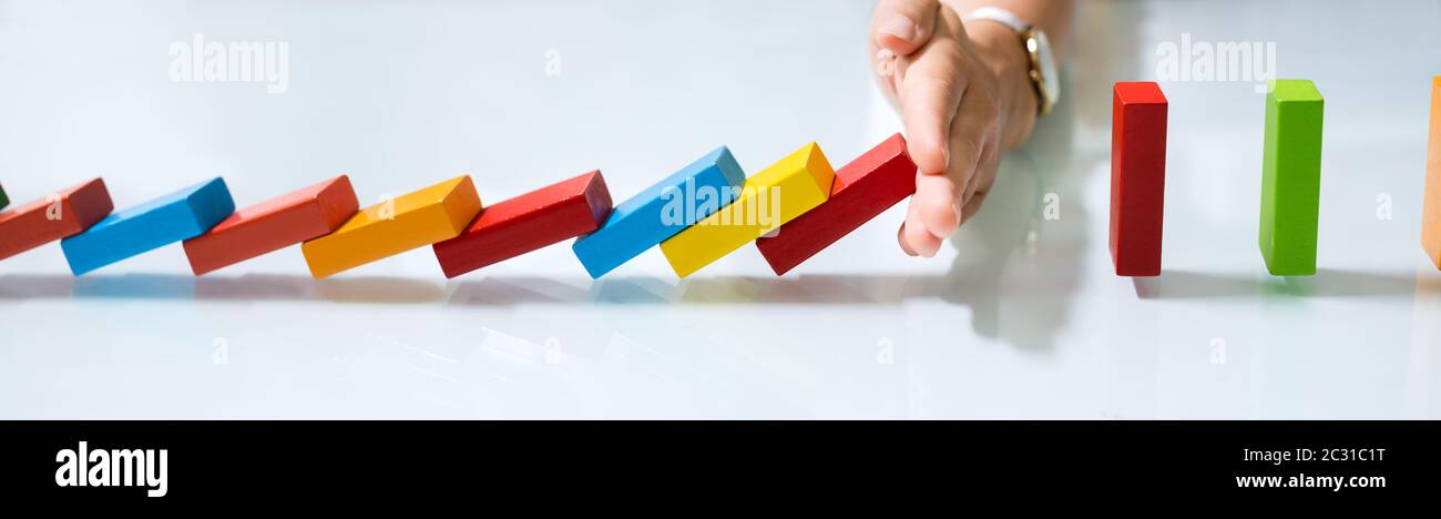 Stop Falling Domino. Risk Prevention And Management Stock Photo - Alamy