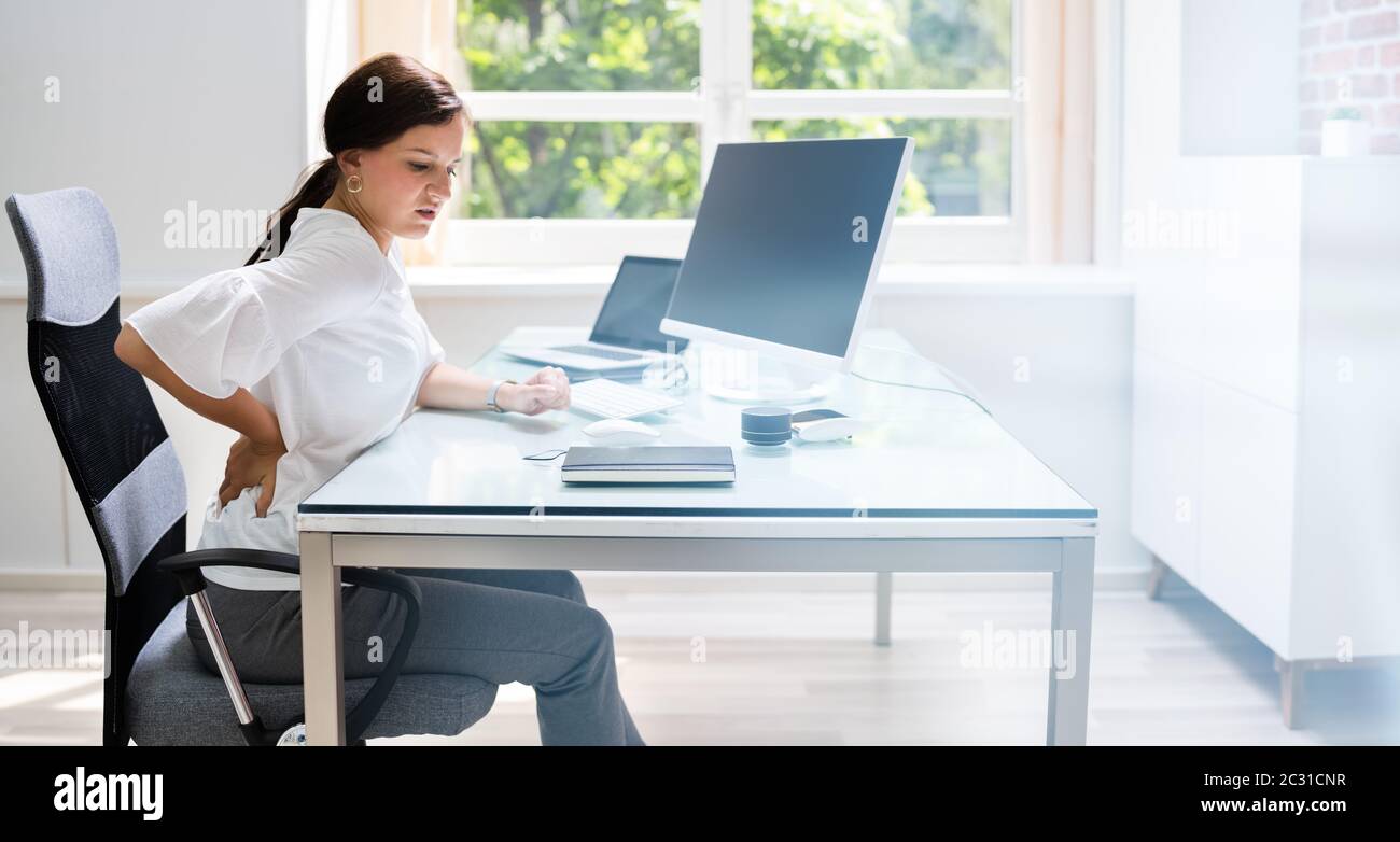 Bad Posture Back Pain While Sitting In Office Stock Photo - Alamy