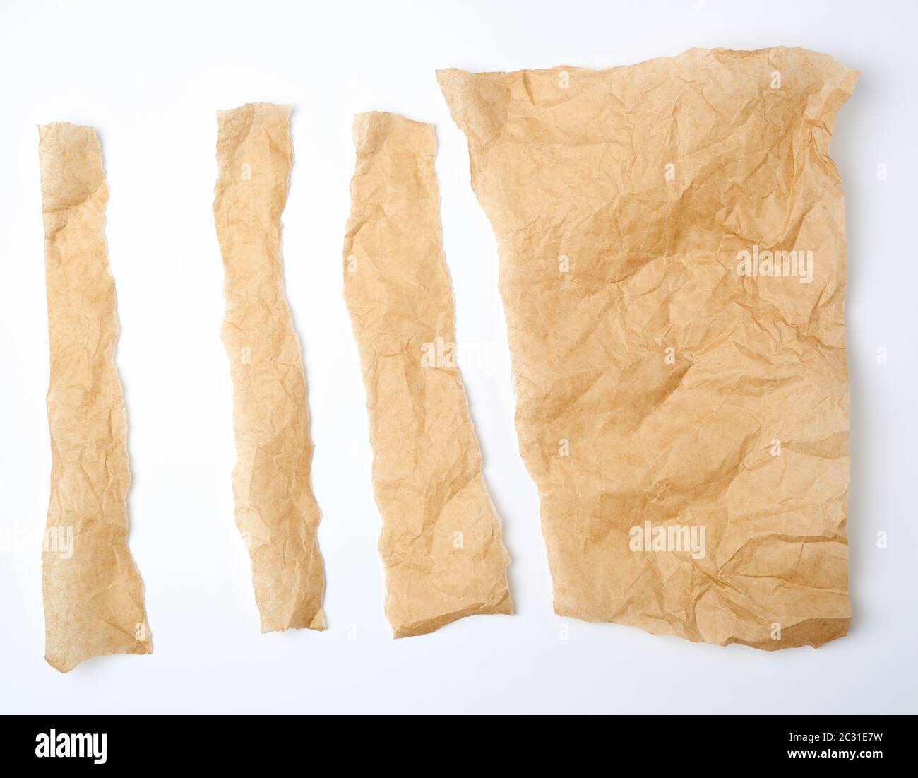 torn brown pieces of parchment paper on a white background, flat lay ...