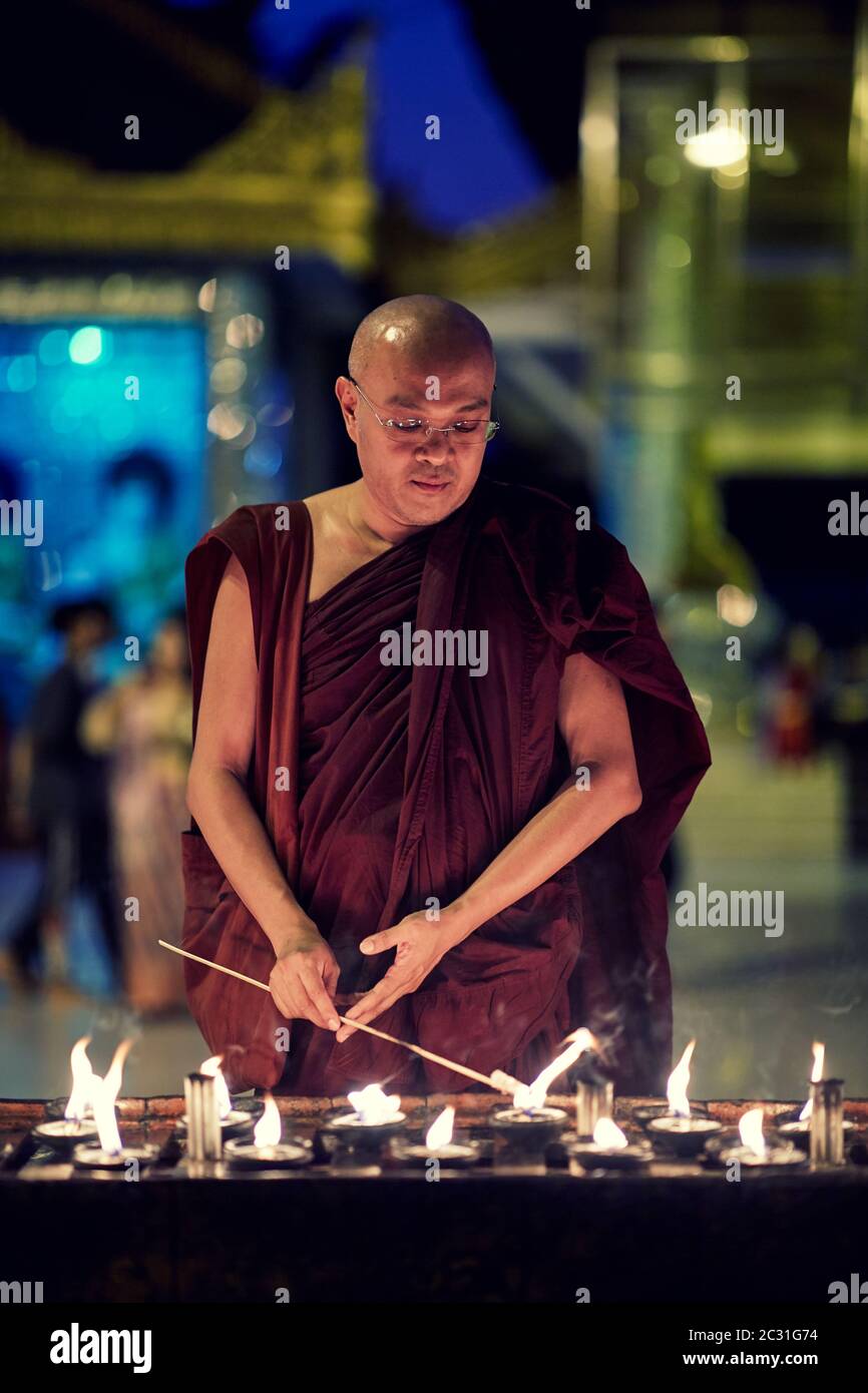 Novice monk praying with candles hi-res stock photography and images ...