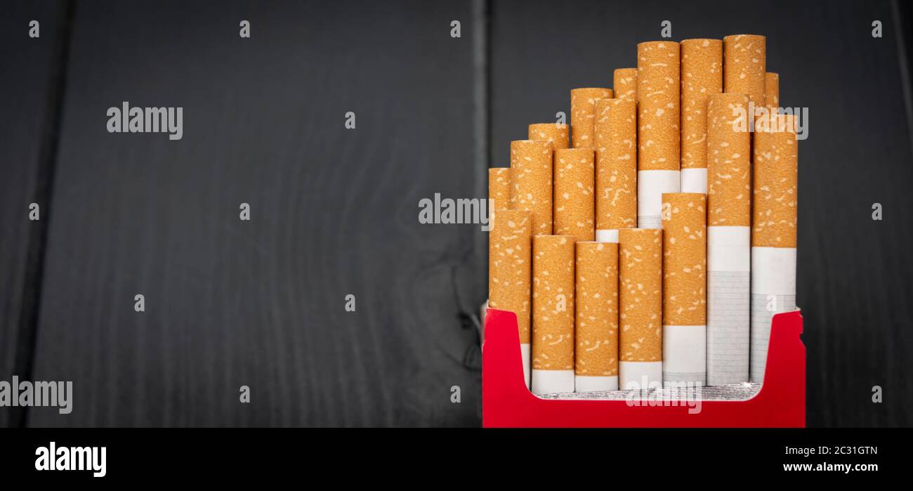 Open cigarette with filters pack on gray background Stock Photo - Alamy