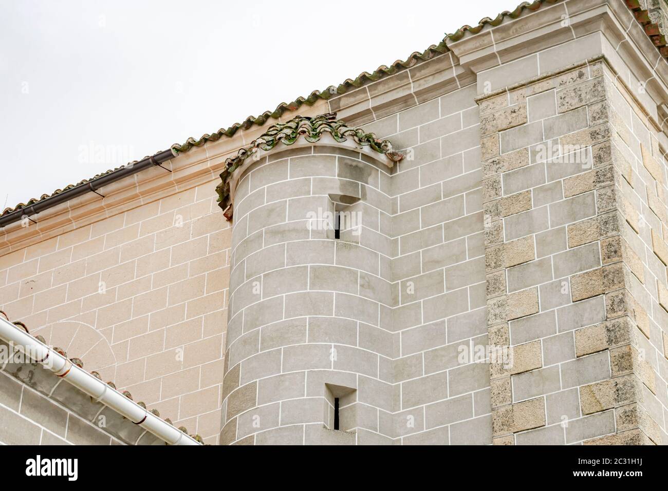 Side facade of a stone church with a rounded ledge to provide space for ...