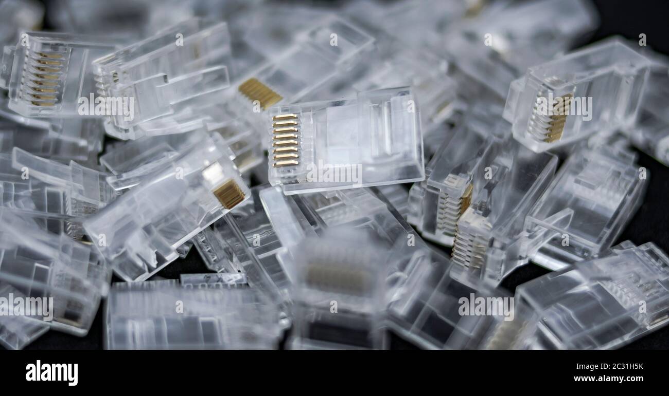 RJ45 connectors with gold pins stacked and ready to be assembled and ...