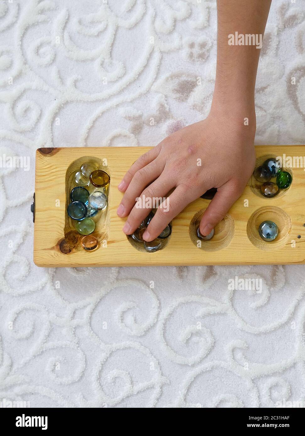 old intelligence games, wooden mancala game, a person playing mancala ...