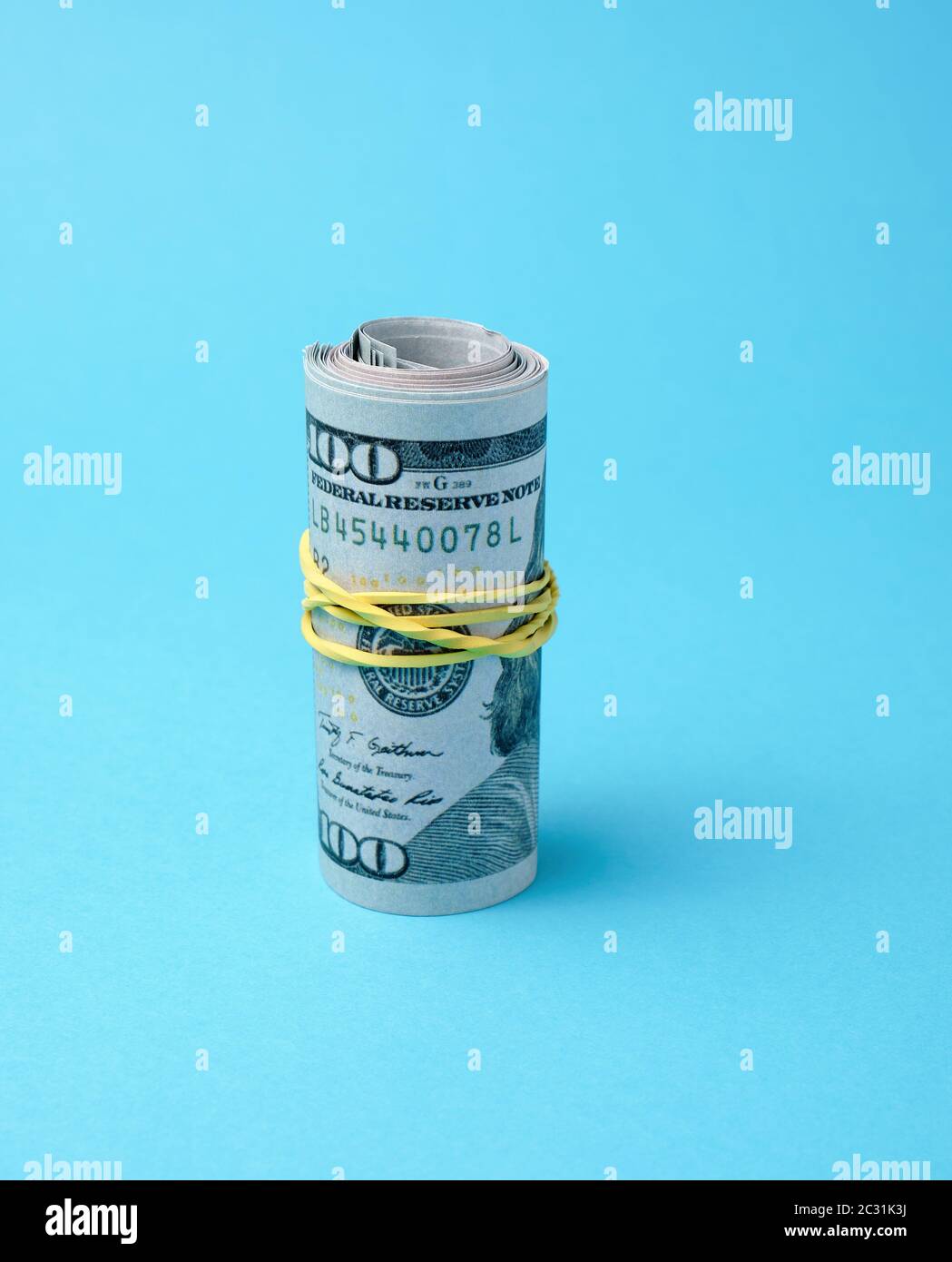rolled up and connected rubber band banknotes of american dollars on a ...