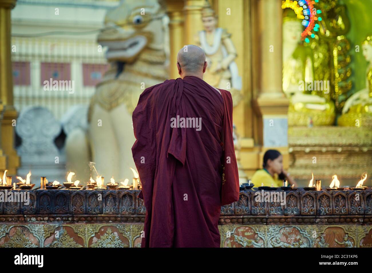 Novice monk praying with candles hi-res stock photography and images ...