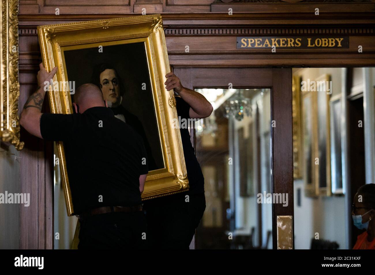 Architect of the Capitol maintenance workers remove a portrait of ...
