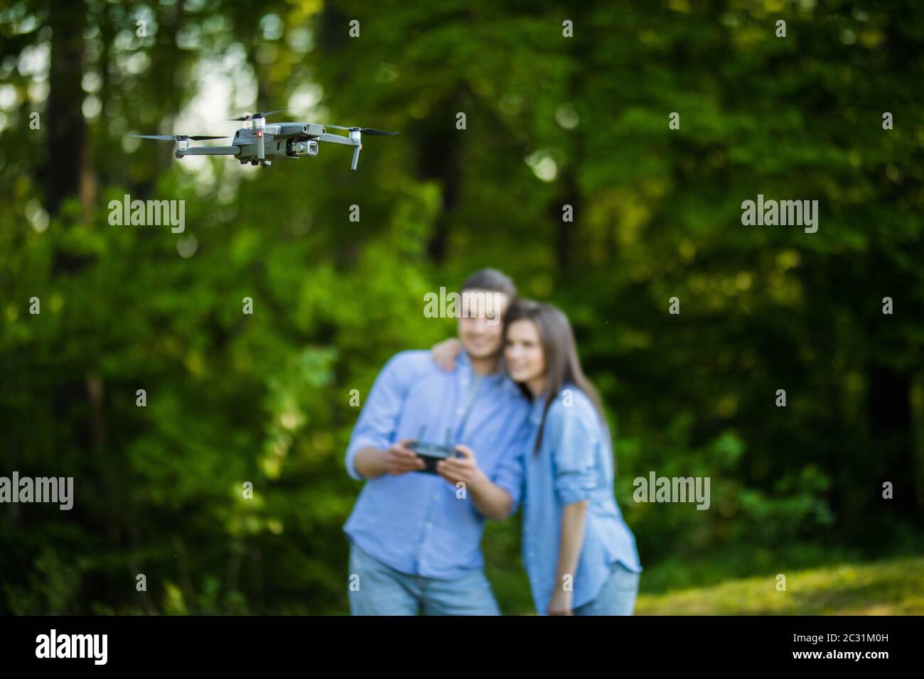 Young couple navigating a flying drone with remote control Stock Photo ...