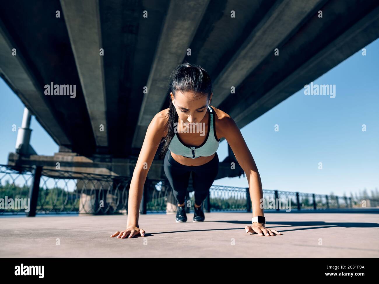 Young athletic woman doing push ups outdoors in urban city background ...