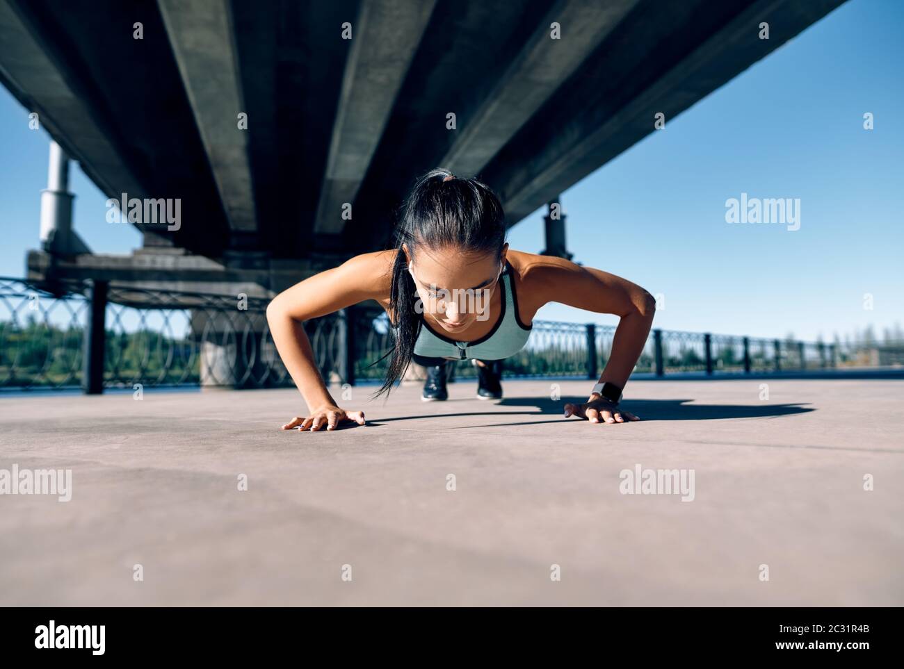 Young athletic woman doing push ups outdoors in urban city background ...