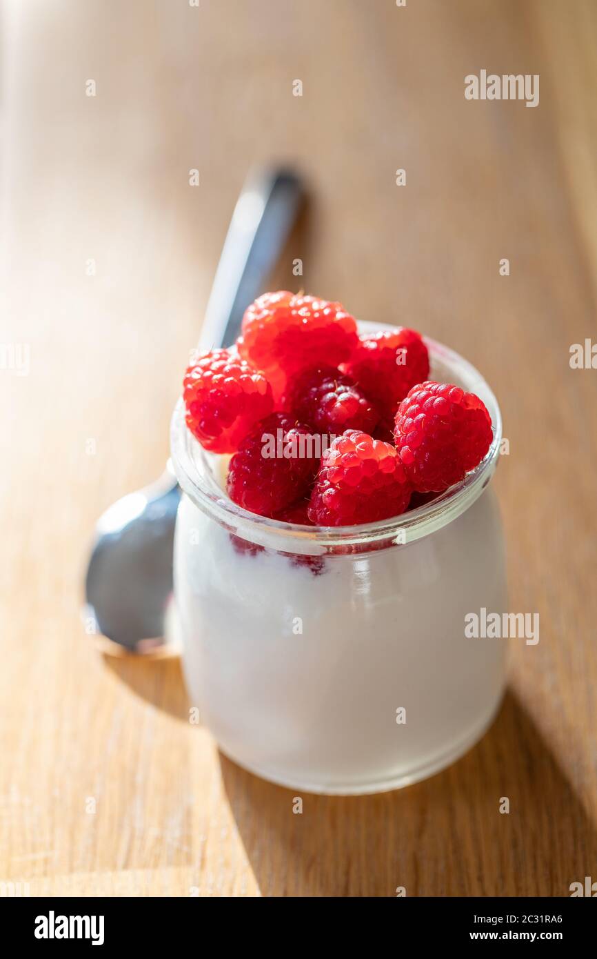 Raspberry yoghurt in glass with spoon Stock Photo - Alamy