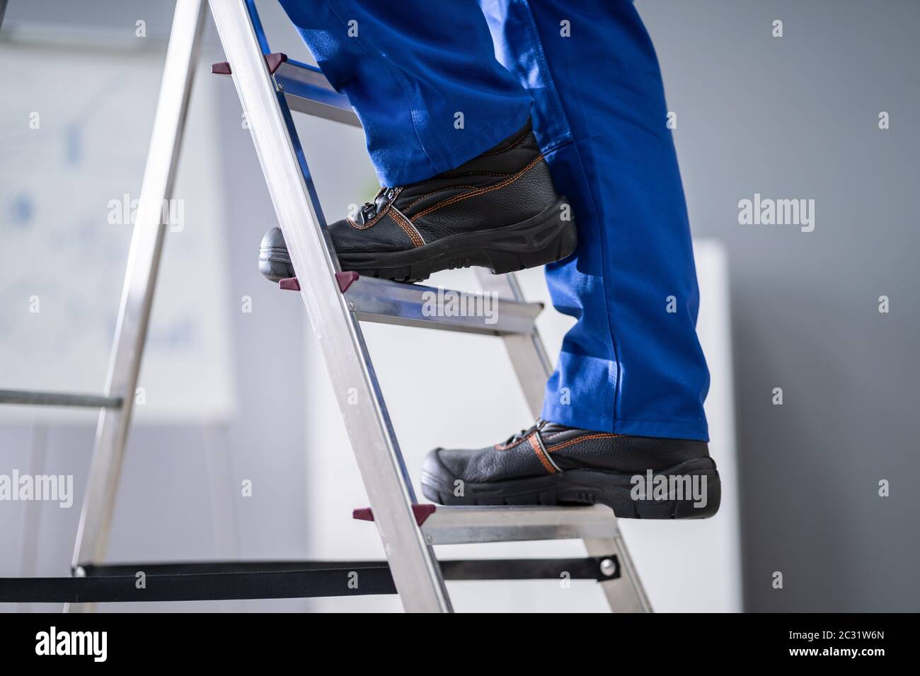 Low Section View Of A Handyman's Foot Climbing Ladder Stock Photo - Alamy