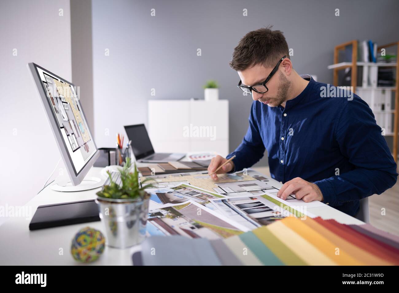Side View Of Real Estate Designer Working On Computer In Office Stock ...