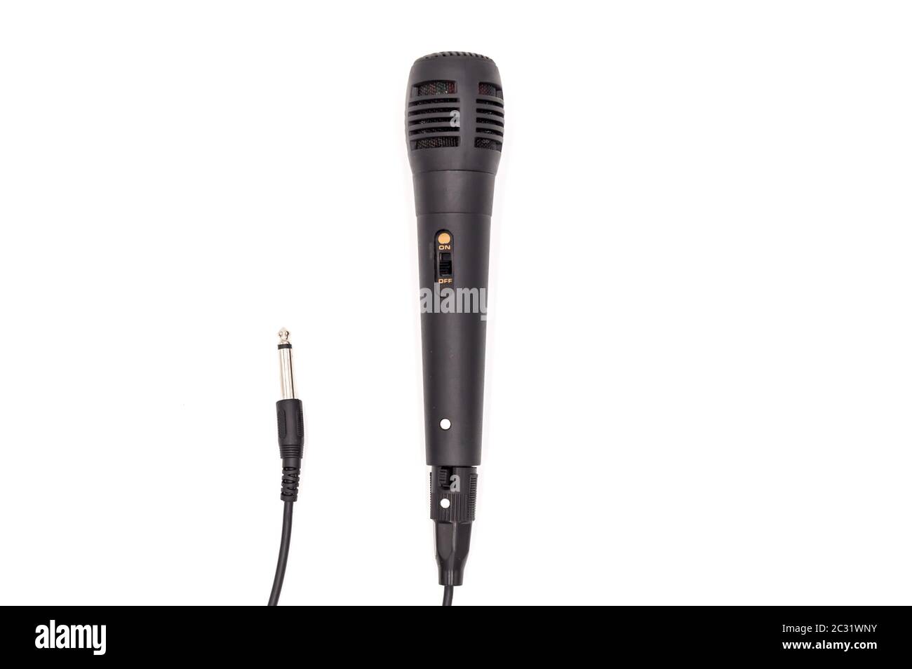 Black karaoke microphone with its connection plug on a white background ...
