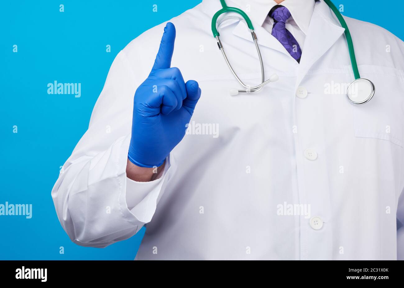 male doctor in white coat, blue medical gloves shows hand gesture of ...
