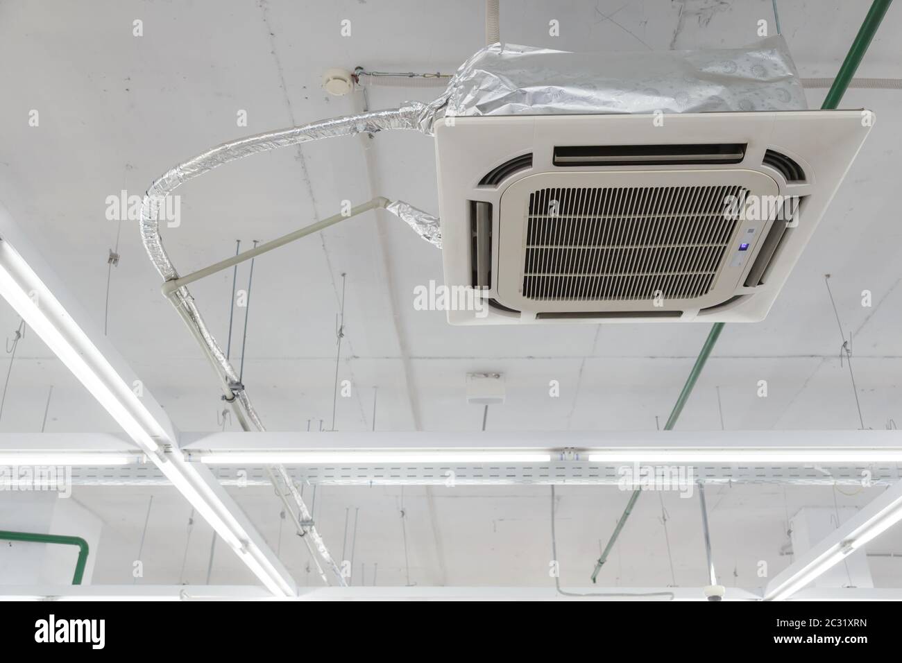 Rectangular ceiling air conditioning appliance. Fan Coil hanging on ...