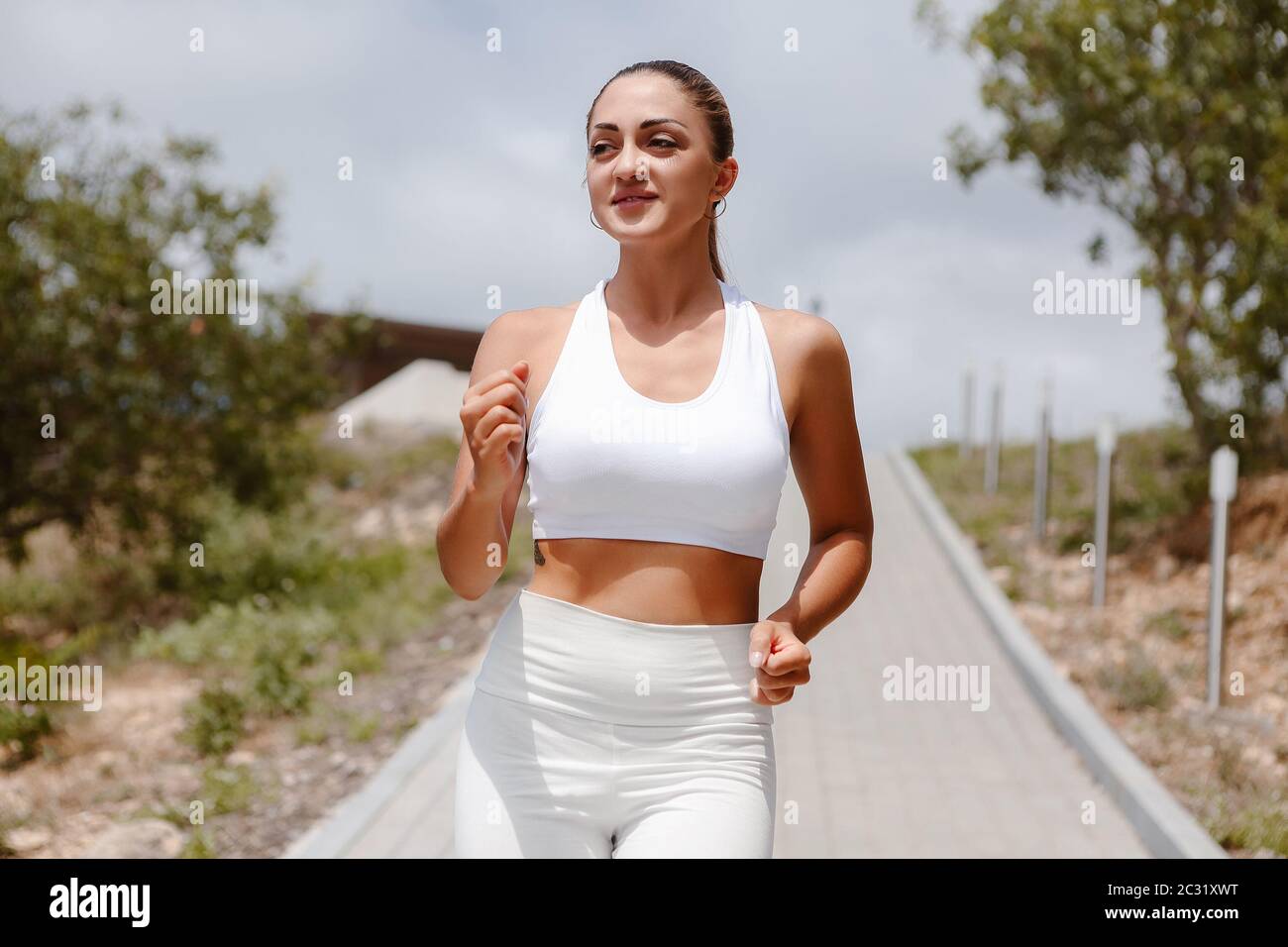 Beautiful young woman running at the beach Stock Photo - Alamy