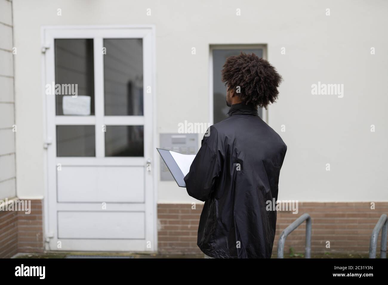 Close-up Of A Person's Hand Filling Document In Front Of House Stock ...