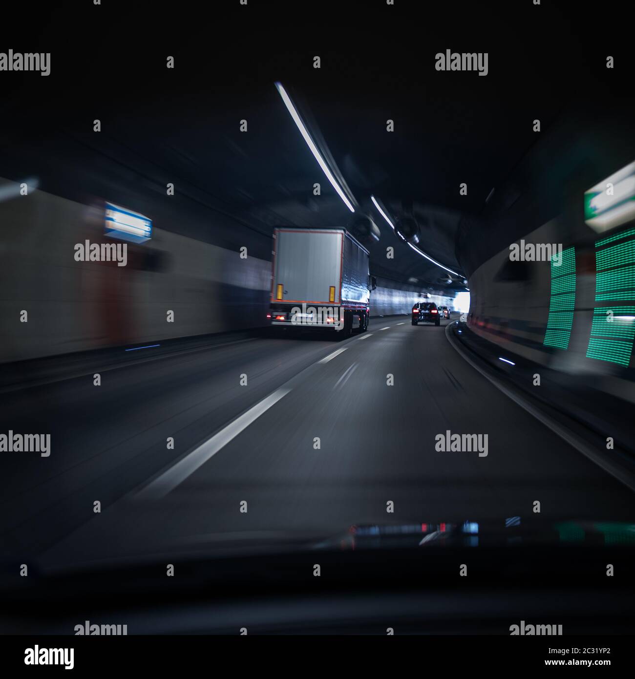 Cars on a highway going through a long modern tunnel (motion blurred ...