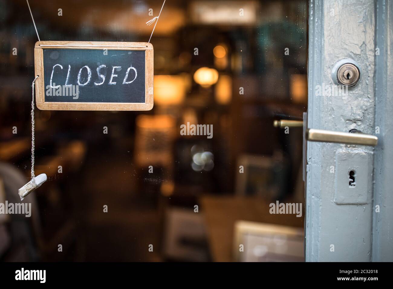 Closed - sign hanging on glass door of a shop in a city Stock Photo - Alamy