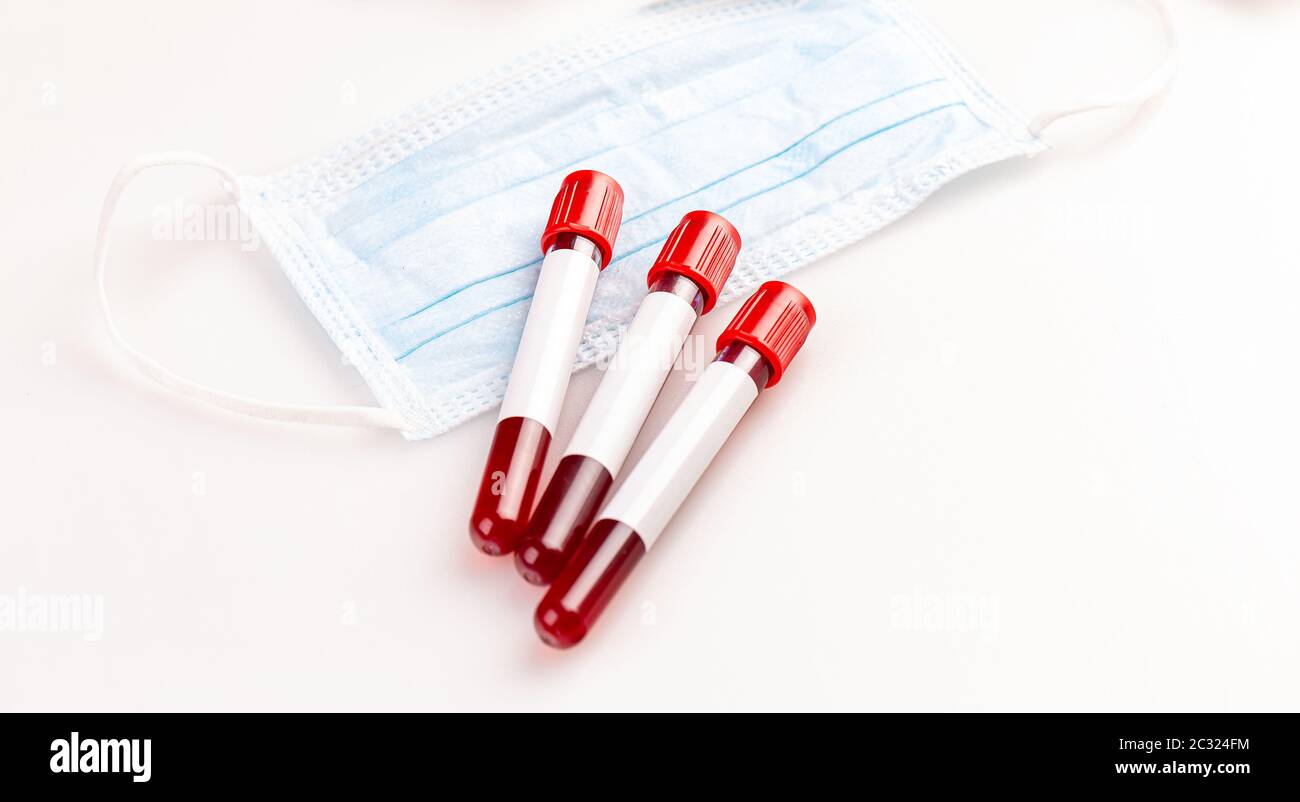 Protection mask with blood sample in test tube with empty white sticker ...