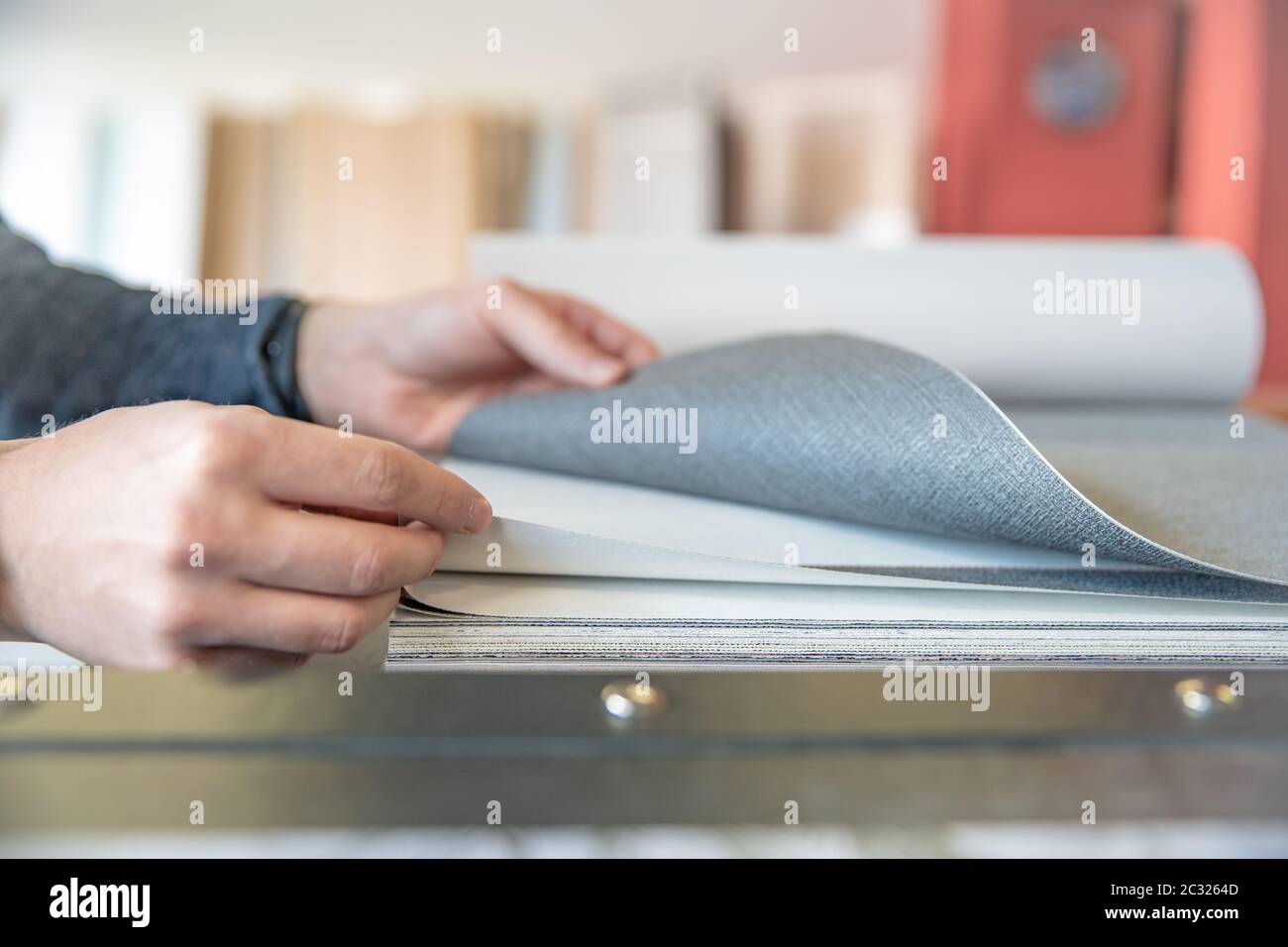 man chooses wallpaper on wall from sample in store Stock Photo - Alamy