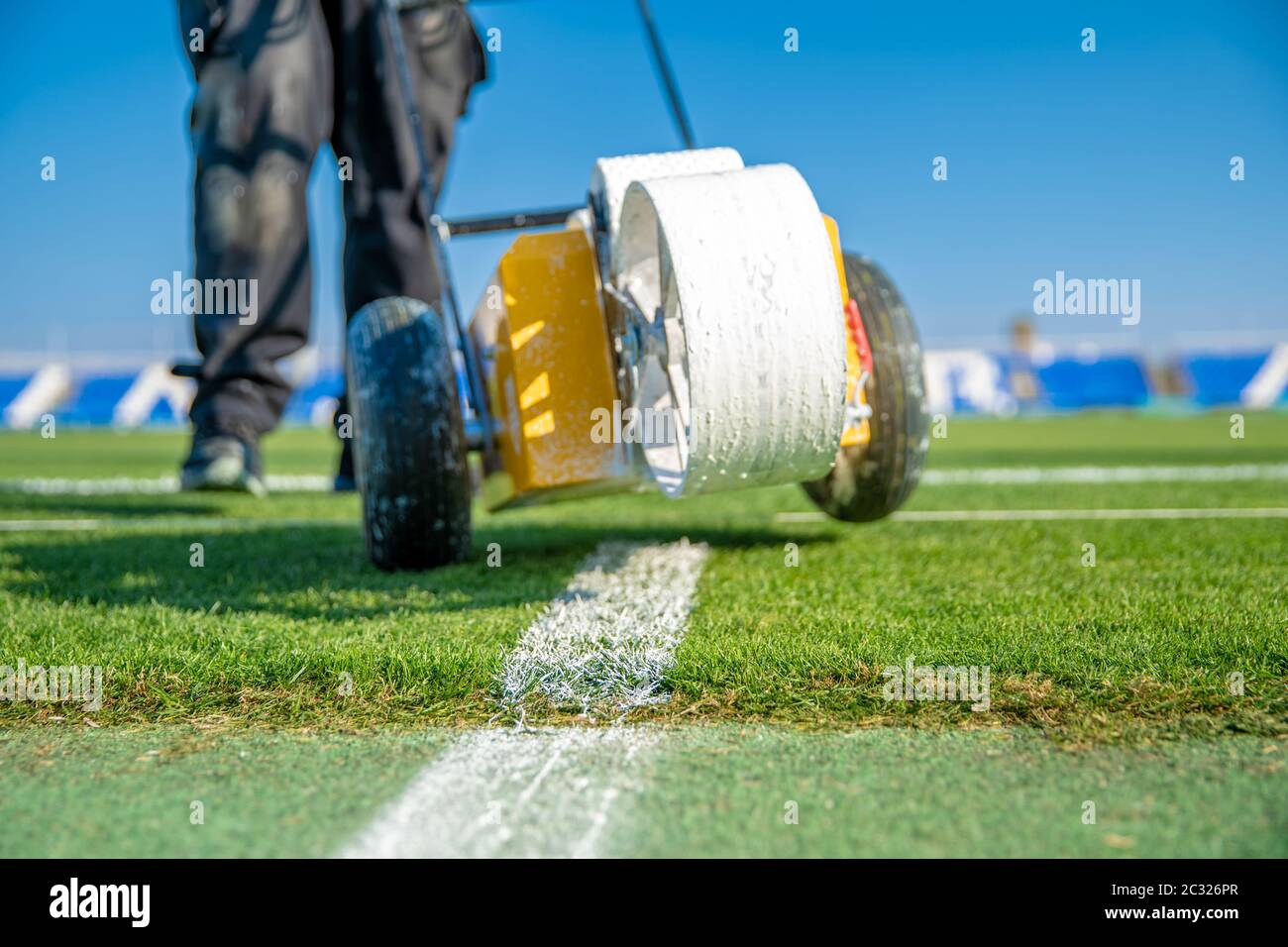 Lining a football pitch using white paint on grass Stock Photo - Alamy