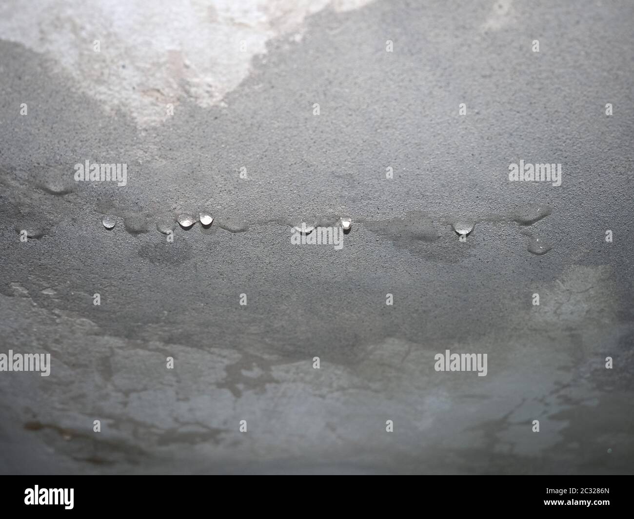 damage caused by dampness and moisture on a ceiling, with droplets of ...