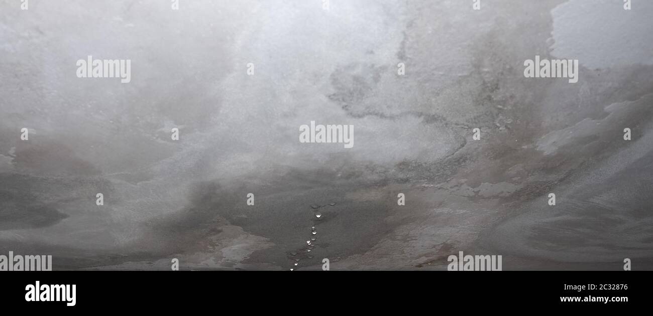 damage caused by dampness and moisture on a ceiling, with droplets of ...