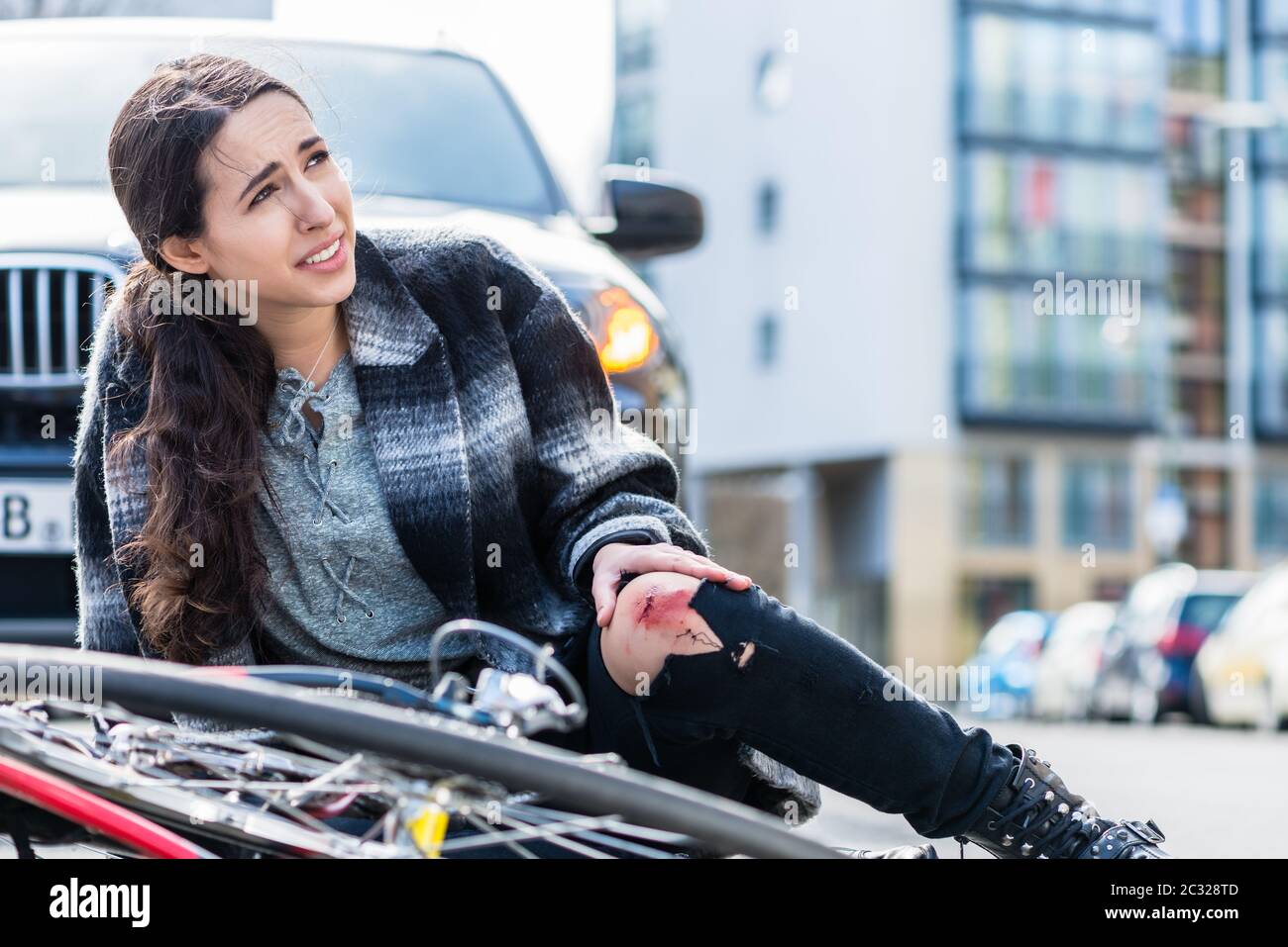 Young woman suffering severe pain caused by knee strain or fracture ...