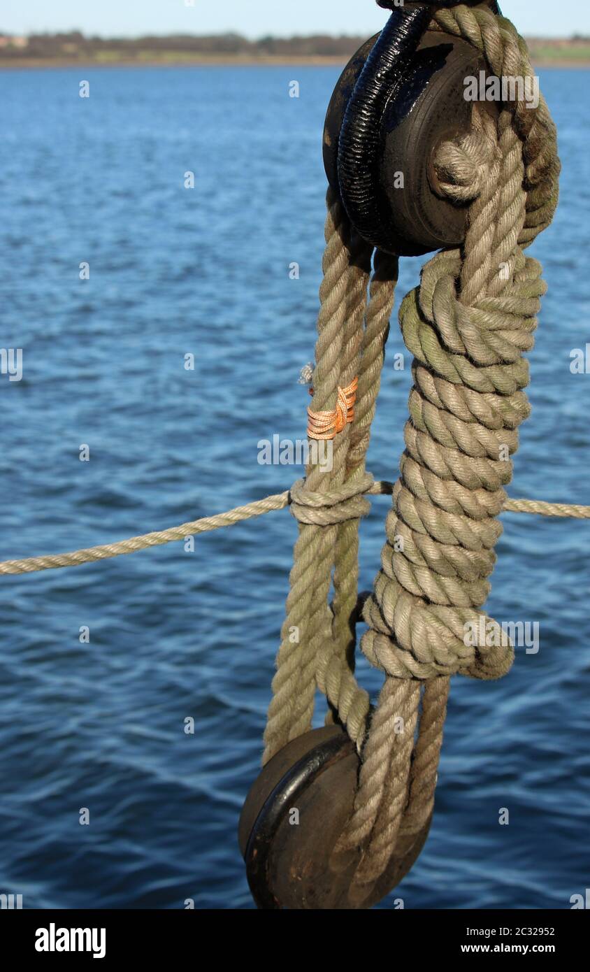 Rope and pulley on sailing ship with a background of river water and ...