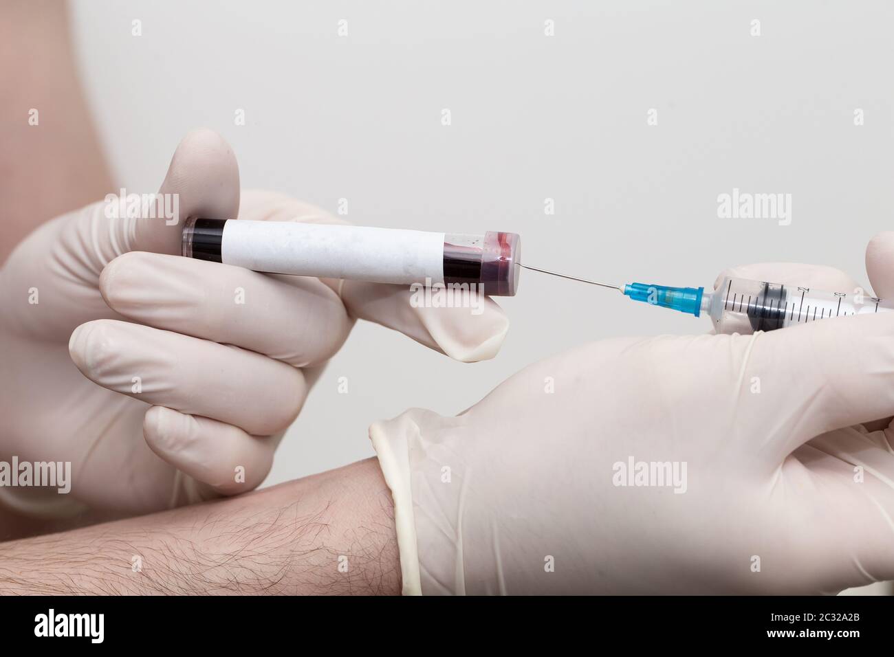 Hand with medical glove of scientist or doctor holds test tube with ...