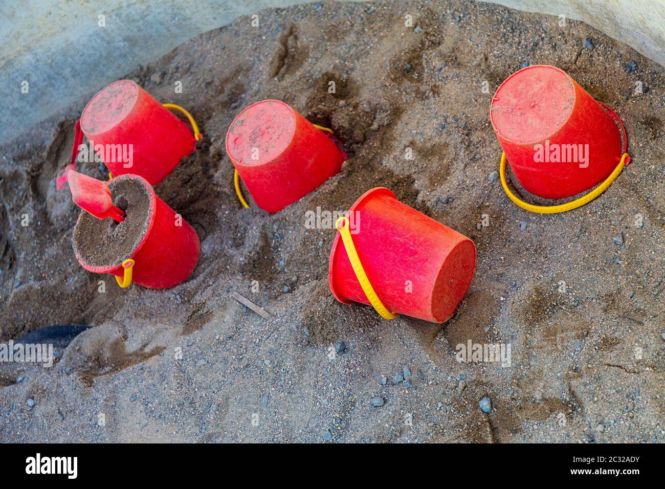 Plastic Red Buckets in Sand Pit Playground Stock Photo - Alamy