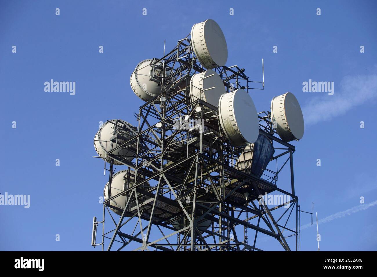 Metal telecommunications mast with aerials and dishes. Background of ...