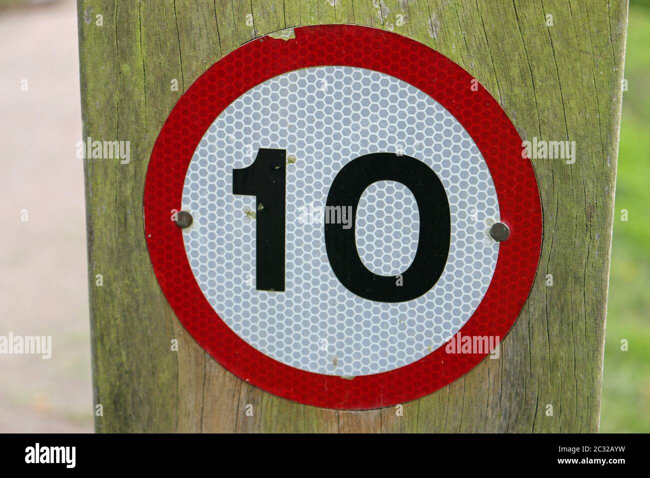 10 mph speed restriction vehicle warning sign on a wooden post ...
