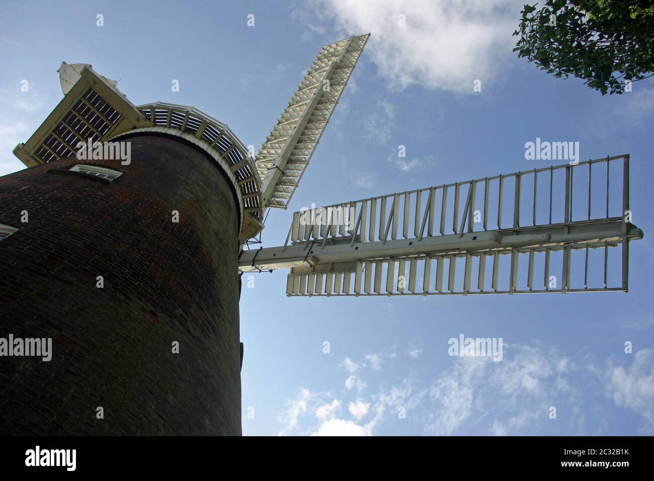 Brick faced windmill seen from below looking up at two sails with a ...