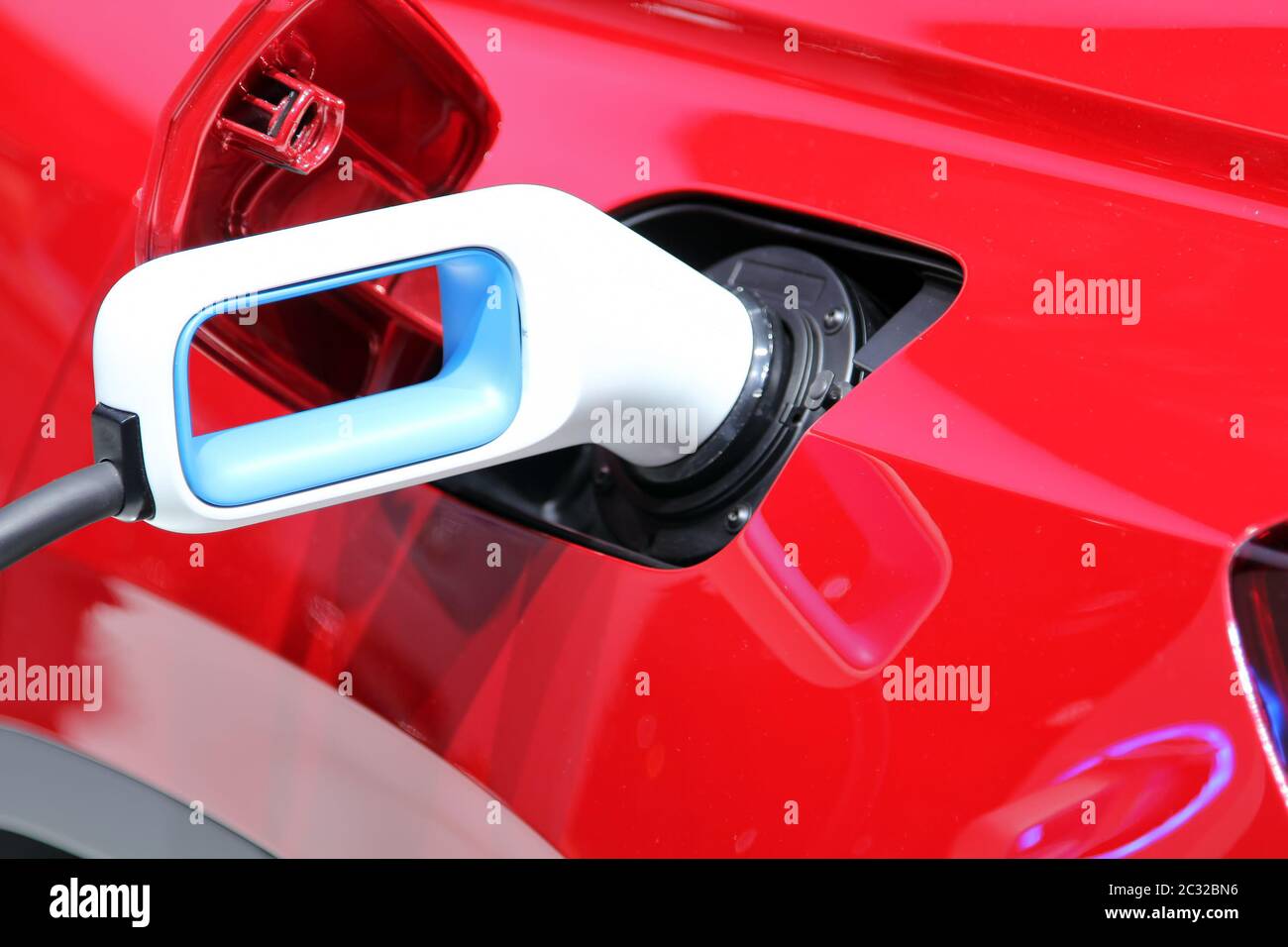 Charging an red EV electric car at charging station, Future of ...