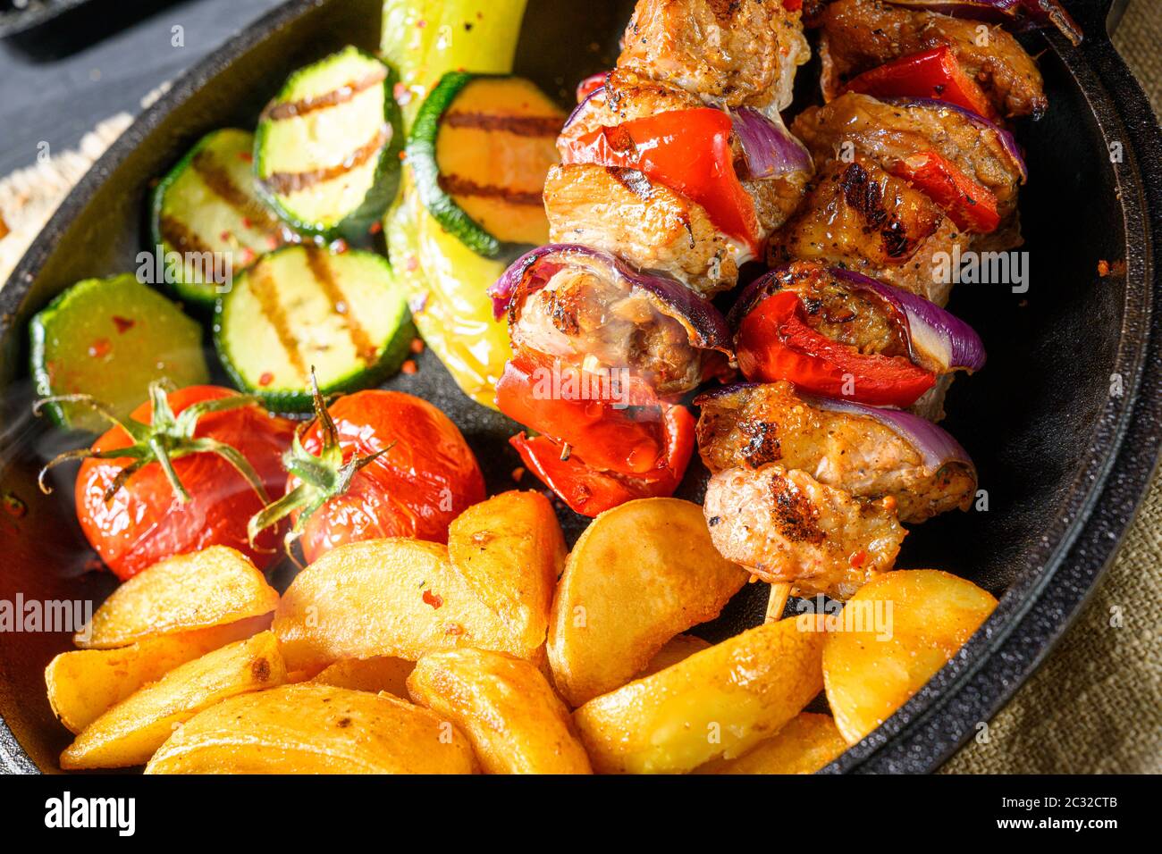 Shish kebab with various vegetables and spice country potatoes Stock ...