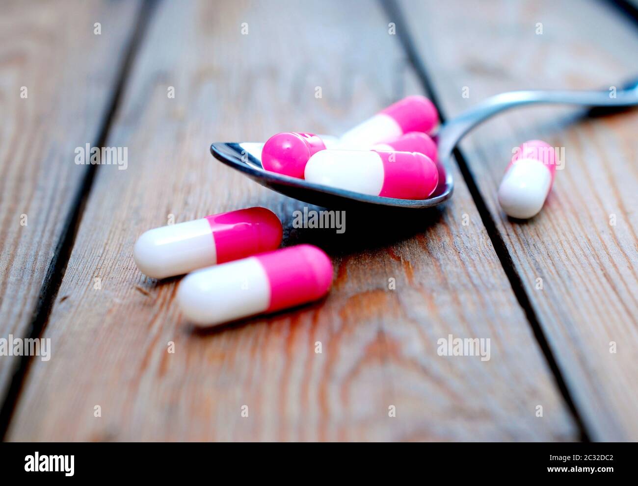 capsules in a spoon on wood background,image Stock Photo - Alamy